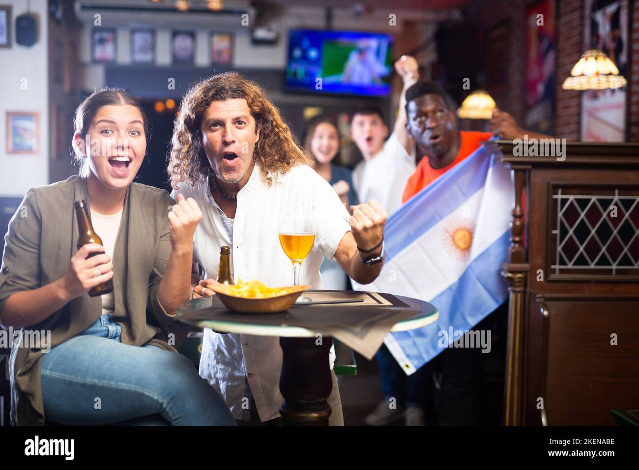 Expressive couple drinking beer and rooting for favorite Argentinean ...