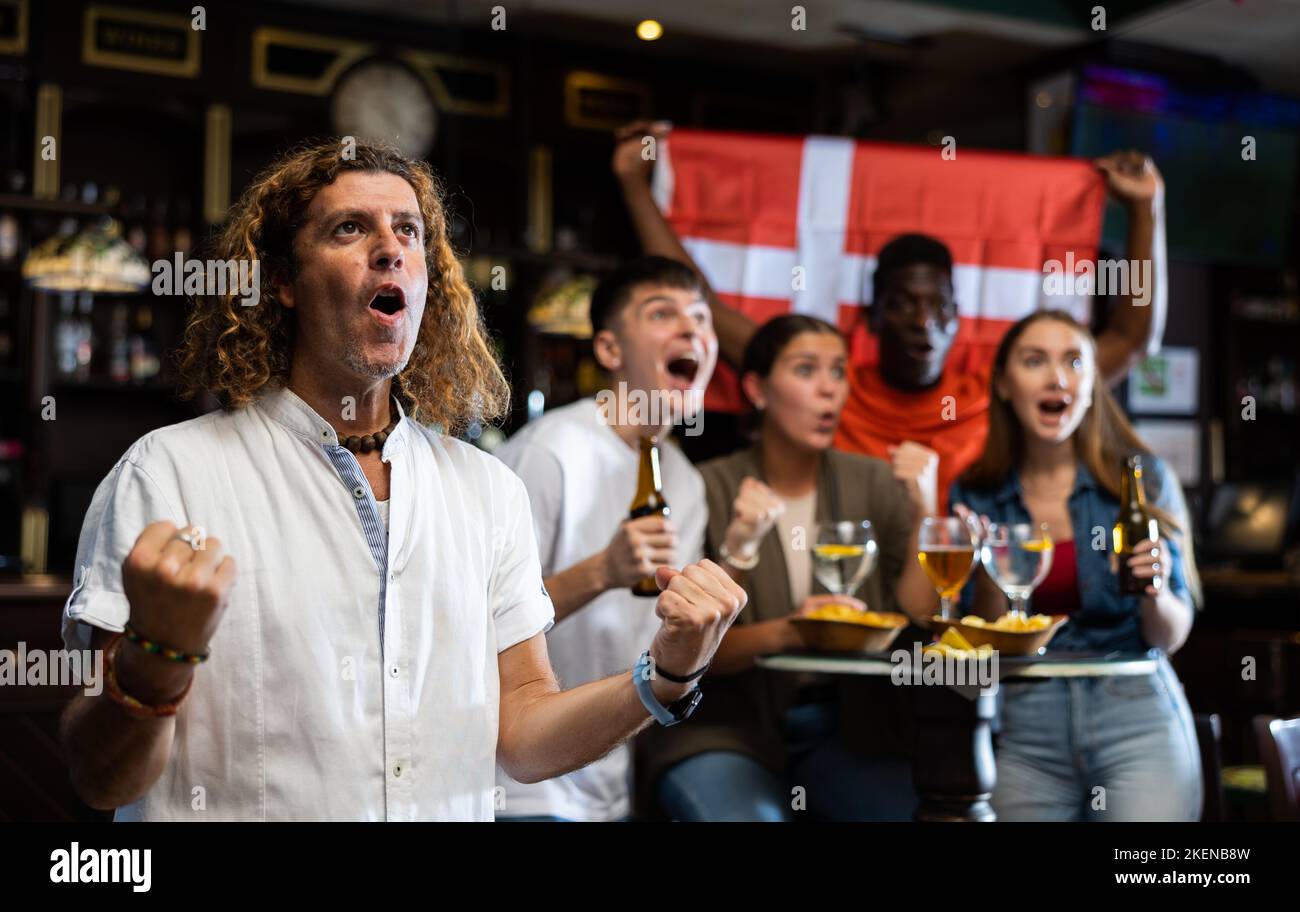 Emotional football fan cheering for team of Denmark while watching ...