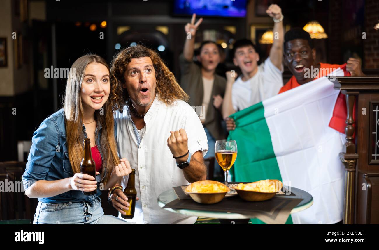 Happy multiracial people holding the flag of Italy and drinking beer in ...