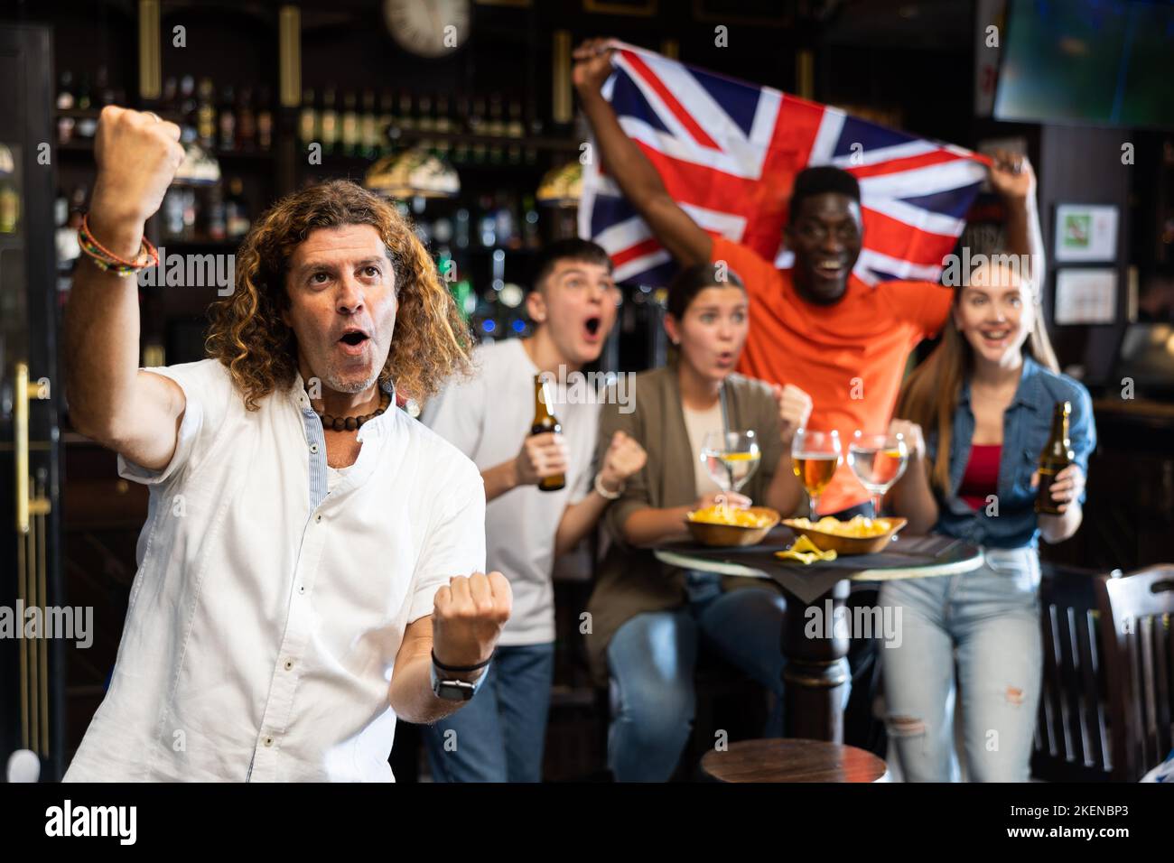 Happy multiracial friends holding the flag of Great Britain, drinking ...