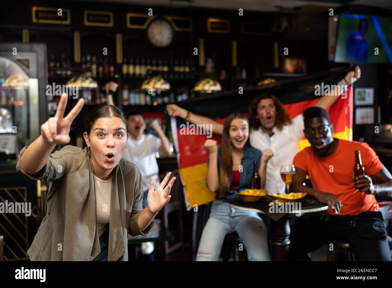 Excited young female fan cheering for German team in sports bar Stock ...