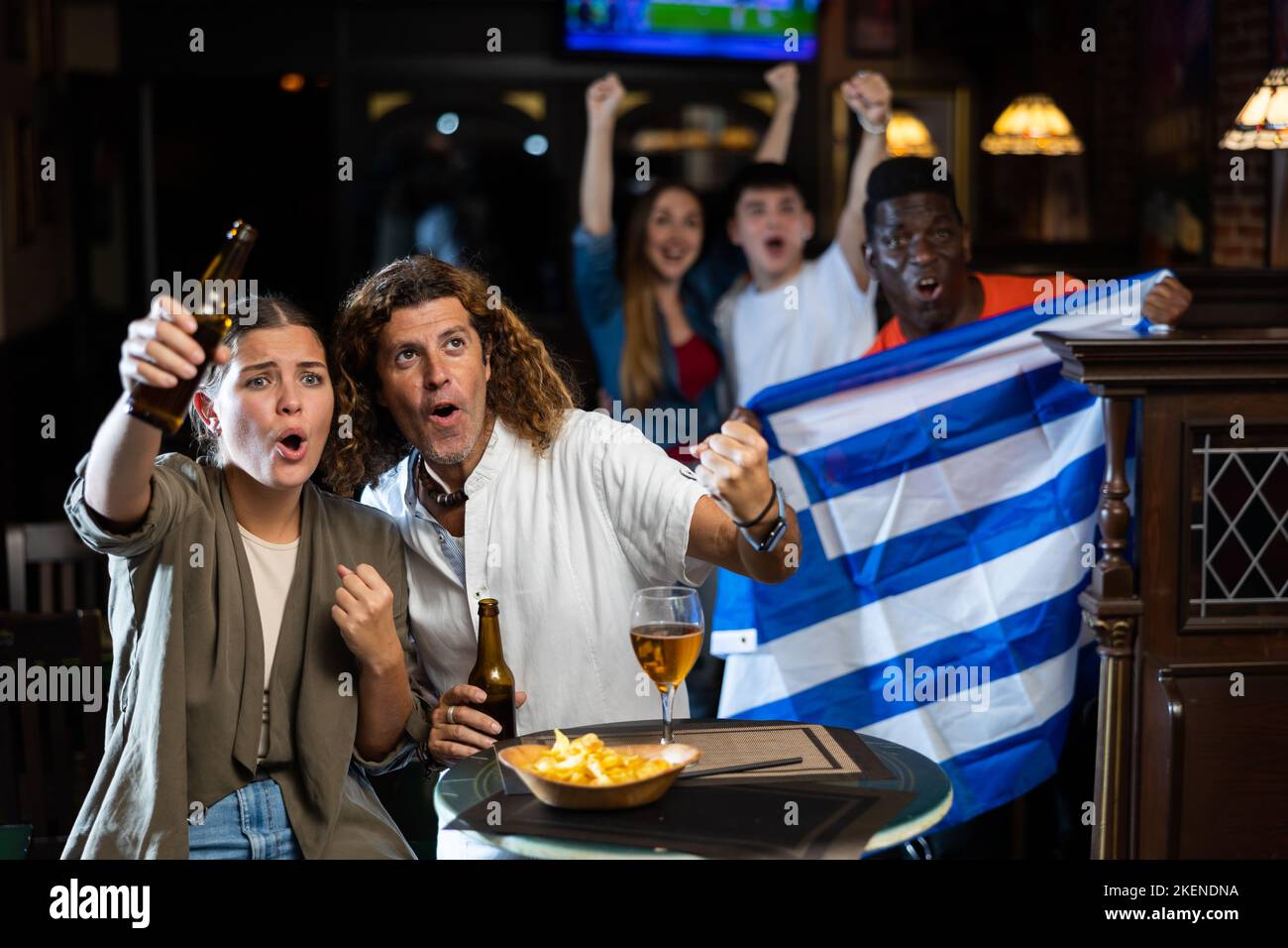Happy multiracial sport fans with flag of Greece with pint of beer and ...