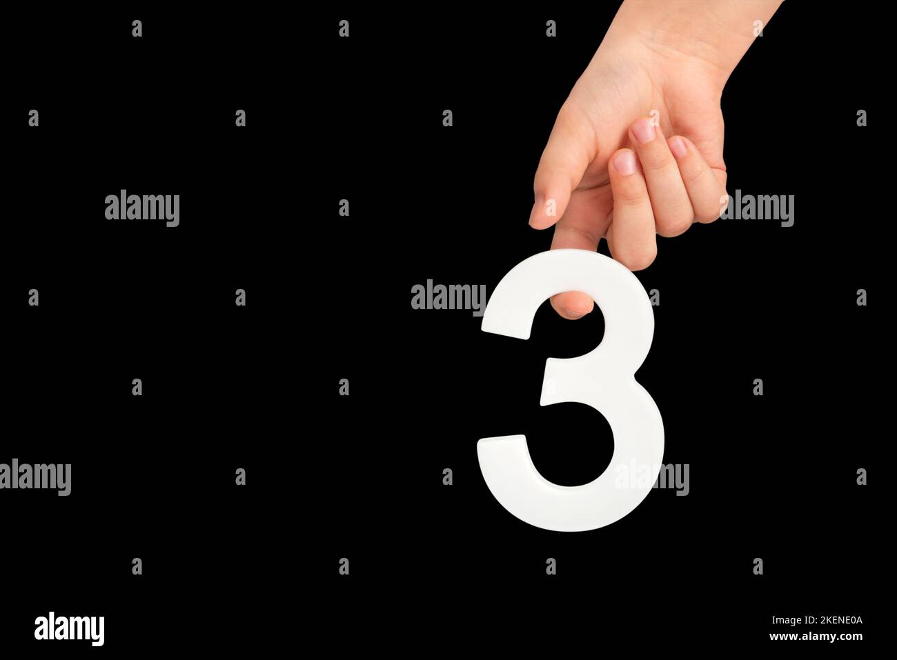 number three in hand isolated on black background. Number three in a ...