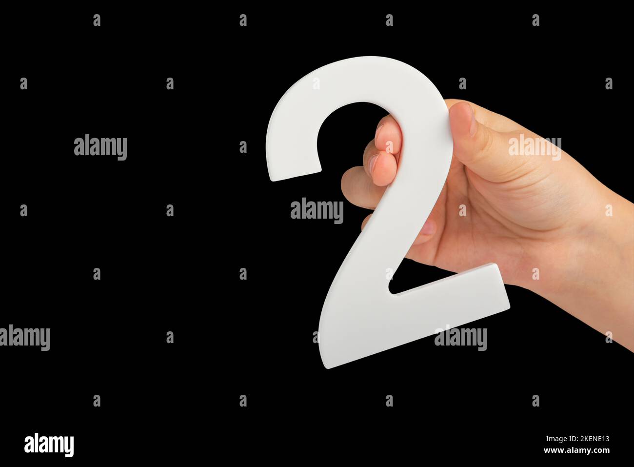 number two in hand isolated on black background. Number two white in a ...