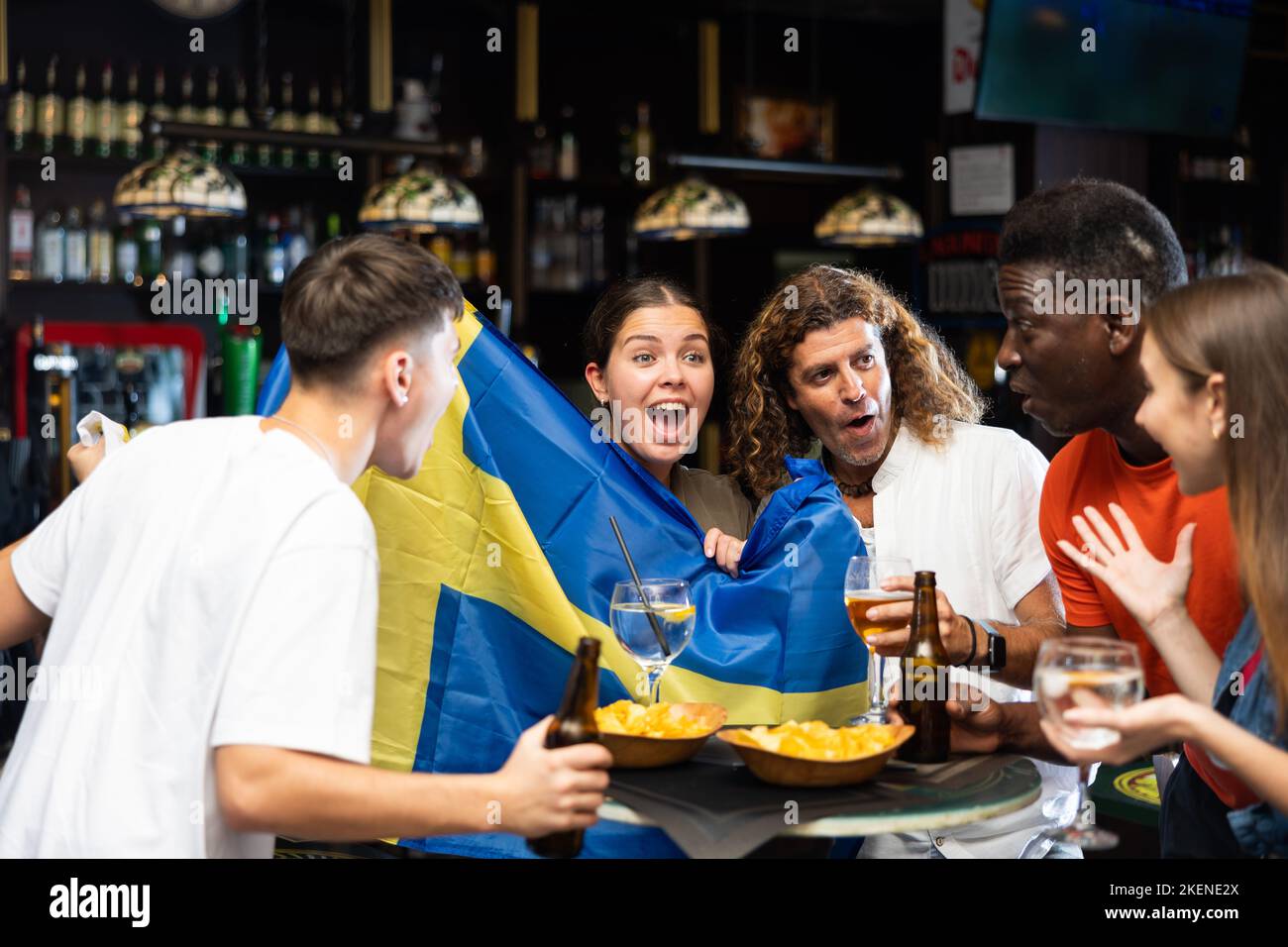 Cheerful international sport football fans holding up Swedish flag and ...