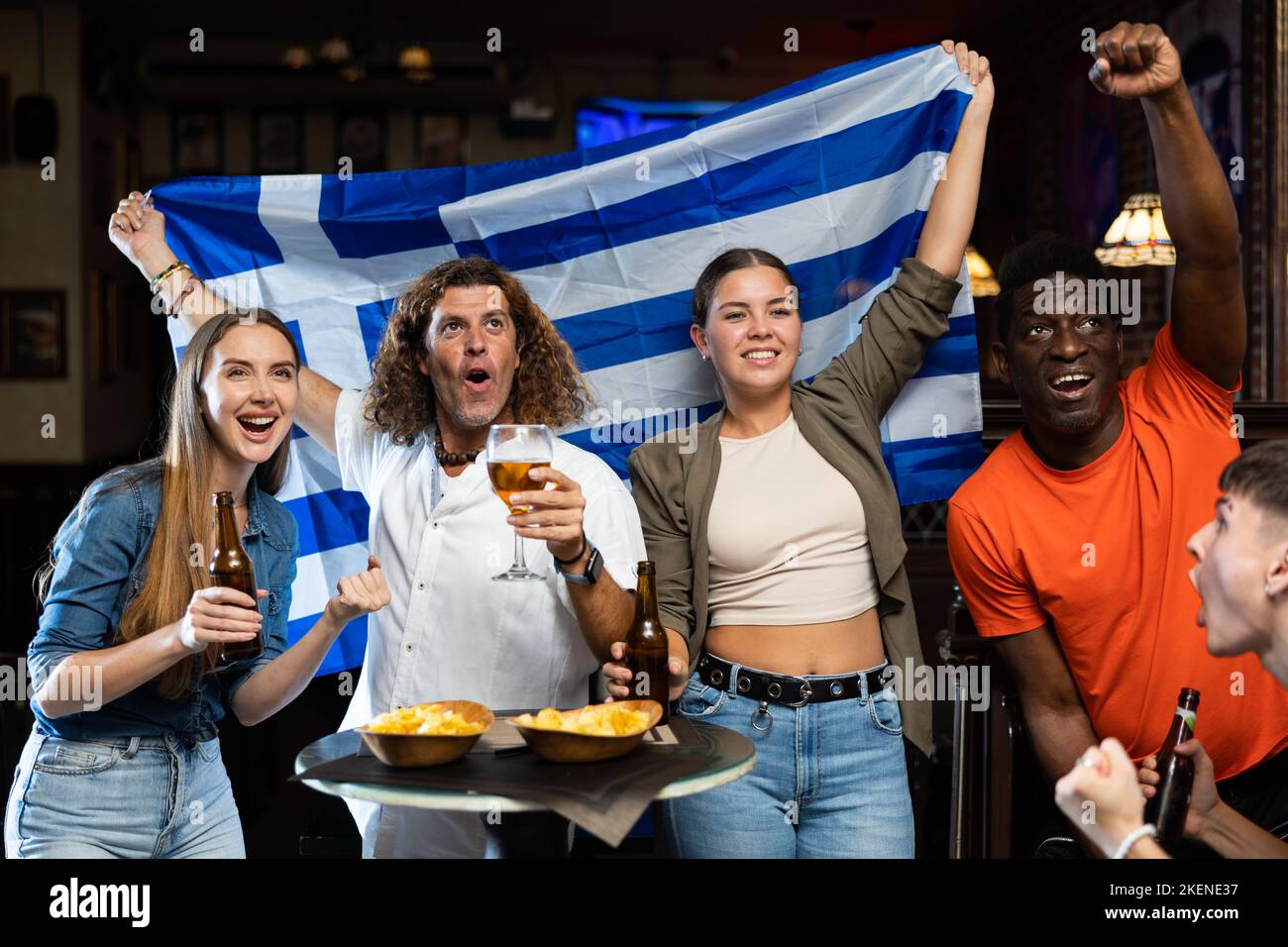 Group of sports fans celebrating victory of favorite team from Greece ...
