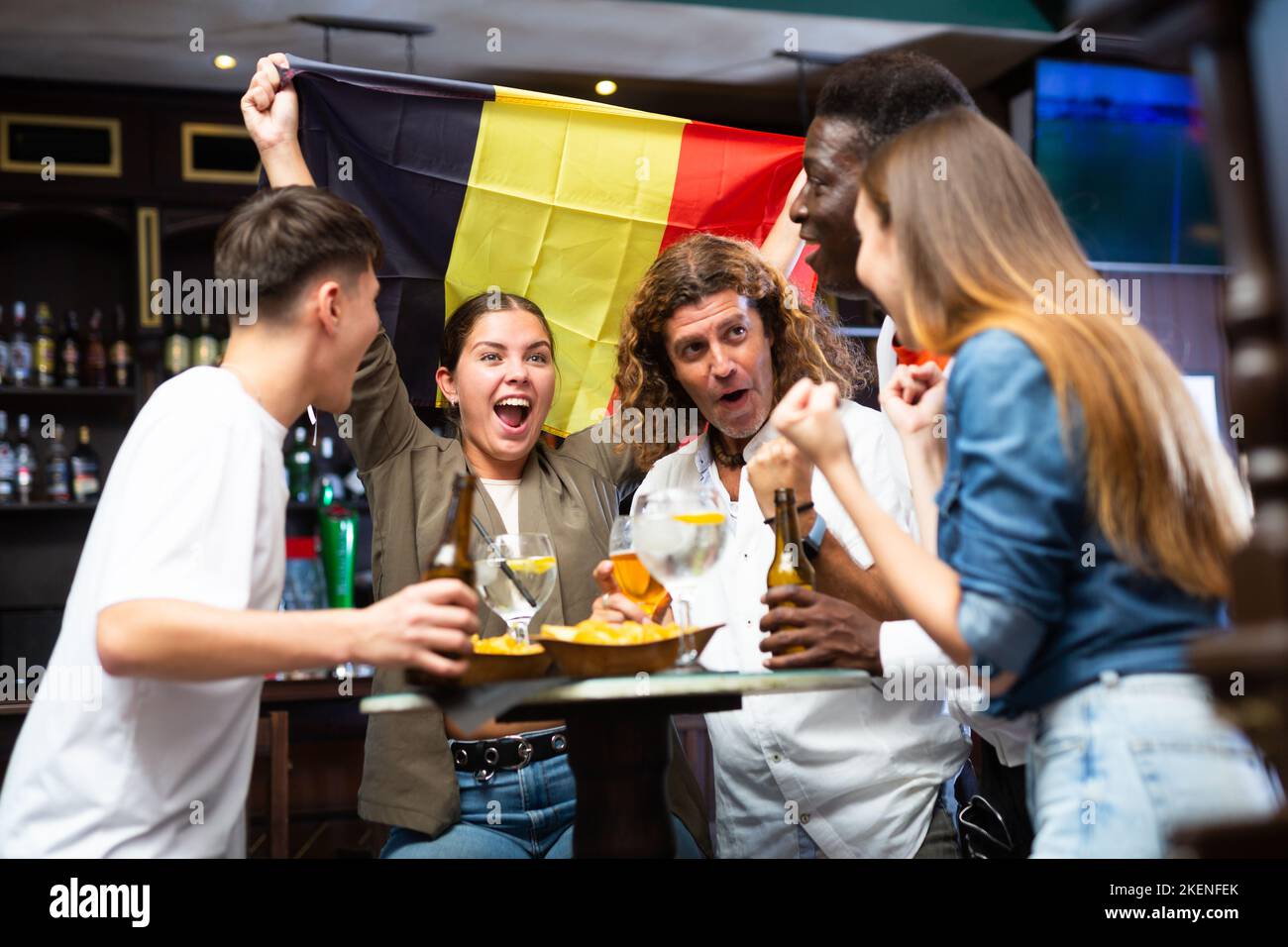 Emotional multiracial sport supporters waving flag of Belgium while ...