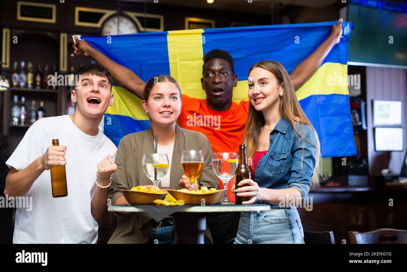 Cheerful people cheering for favorite Swedish sports team in pub Stock ...