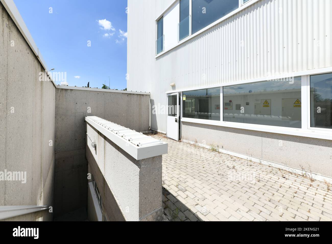 Stairs with aluminum railing next to the facade of an industrial ...