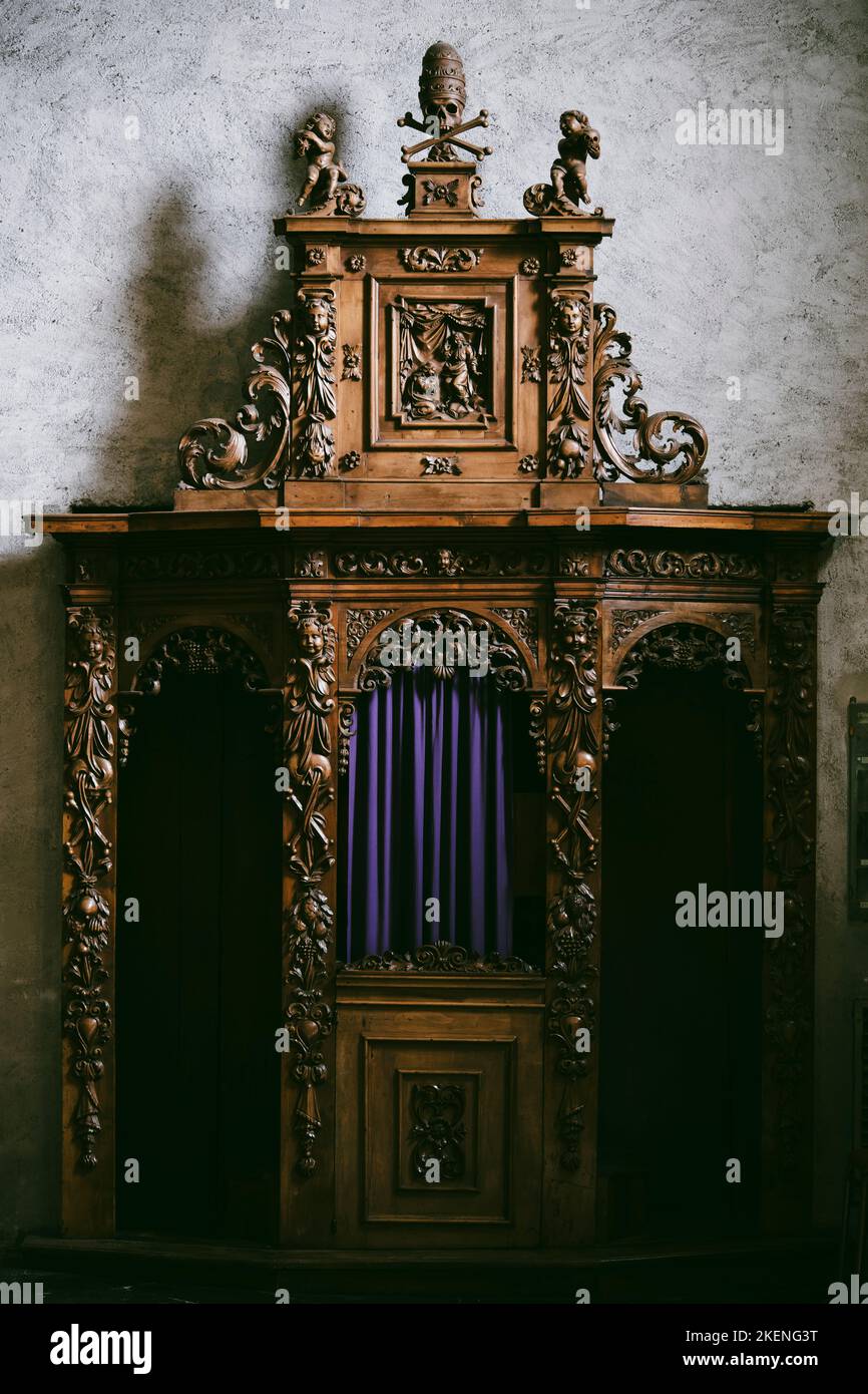 Typical old wooden confession booth at a church, with blue curtains ...