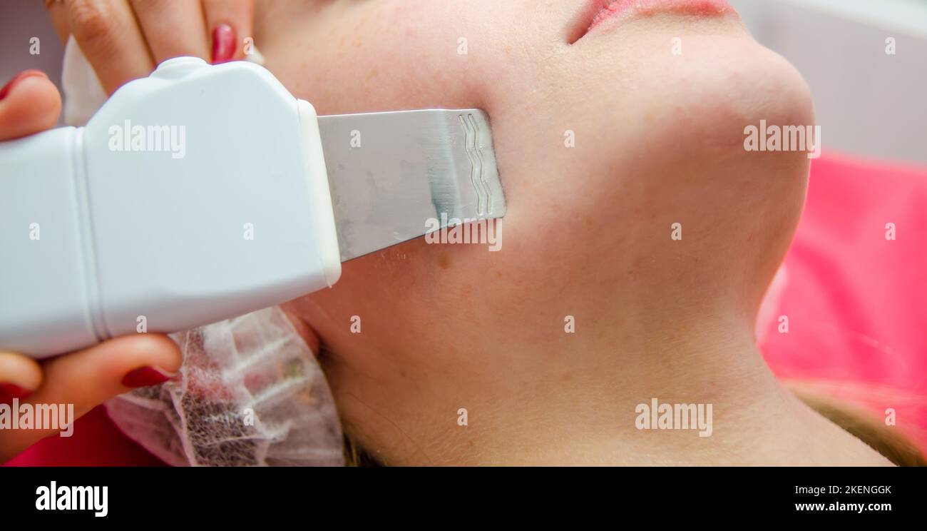 Doctor cosmetologist makes a laser dermal rejuvenation procedure to a ...