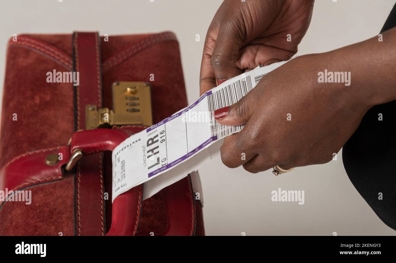 Bangkok, Thailand. 2022. Airline representative attaching a destination ...