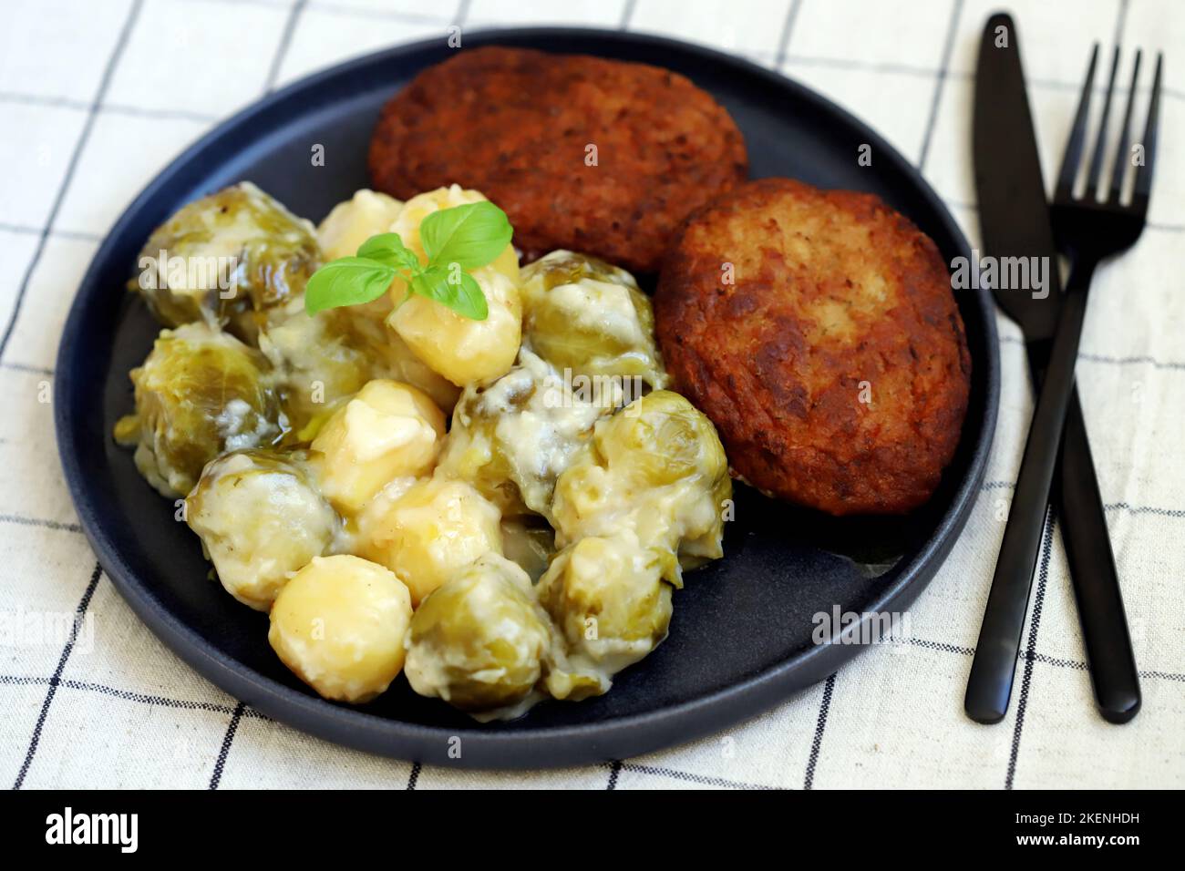 Schnitzels with potatoes and Brussels sprouts in white sauce. A dish of ...
