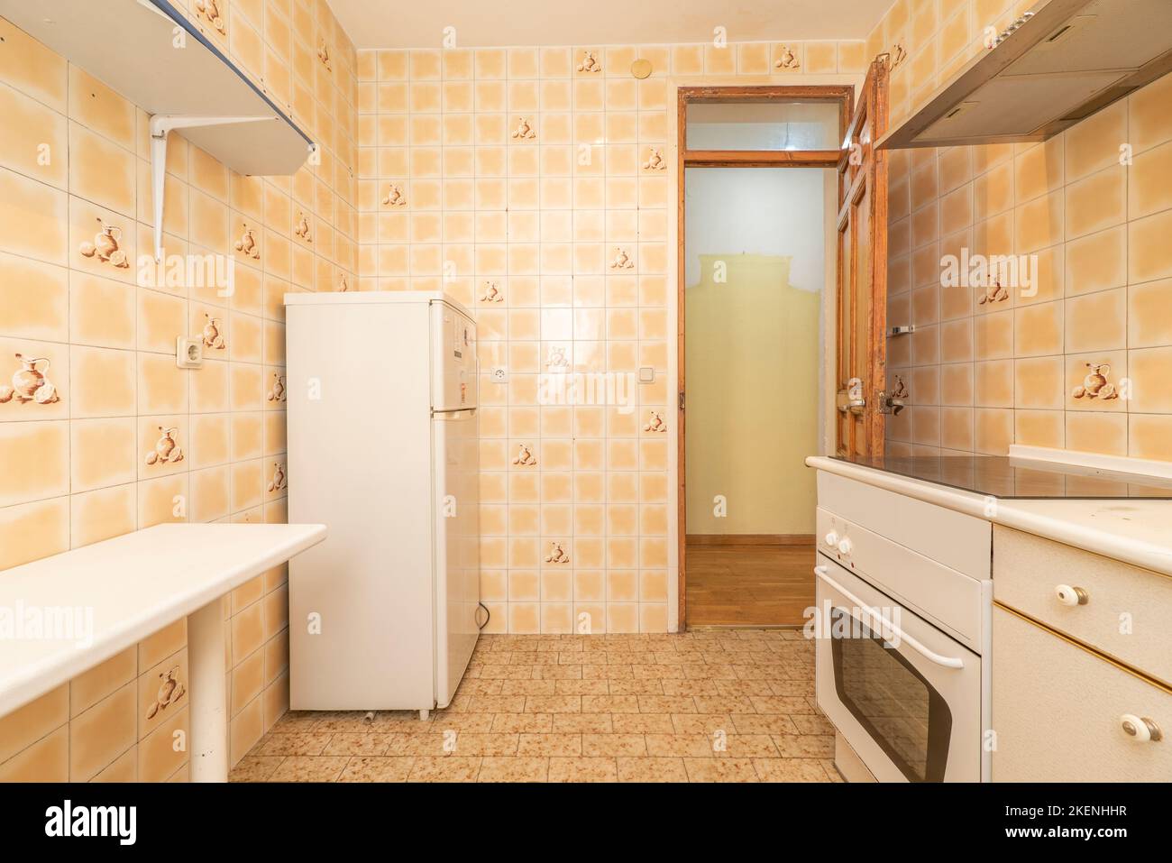 Old apartment kitchen with white cabinets, corner fridge and white claw ...