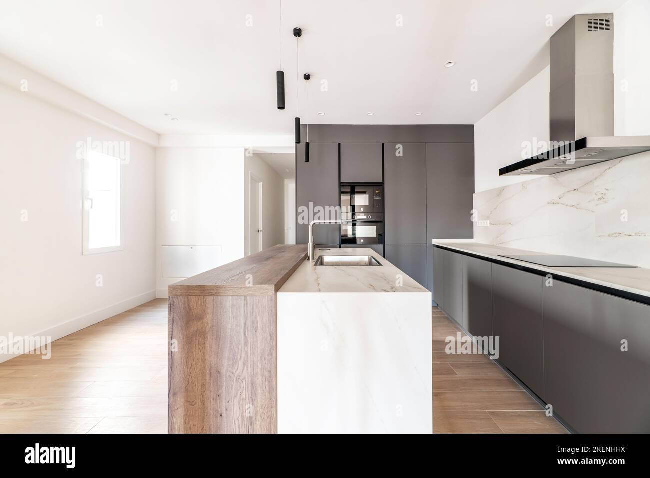 Minimalist kitchen with gray furniture without handles and an island ...