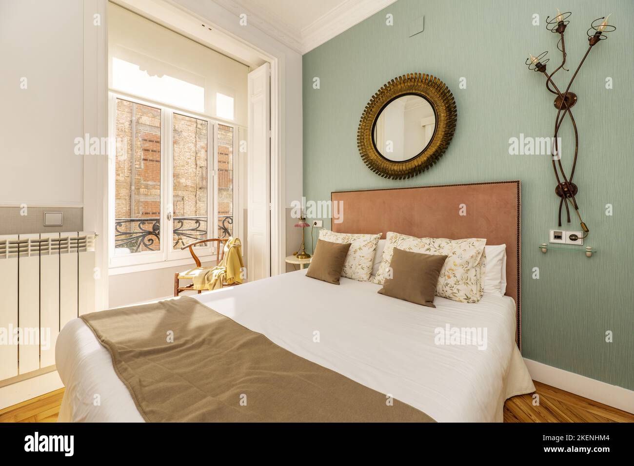 Bedroom with double bed with pink velvet fabric headboard and circular ...