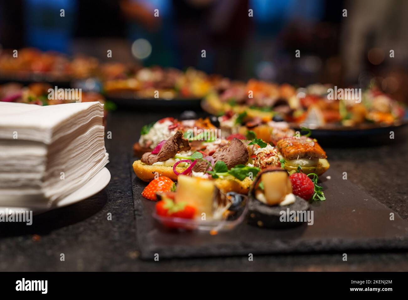 Set of beautiful canapes on black stone plates. Buffet table. Catering ...