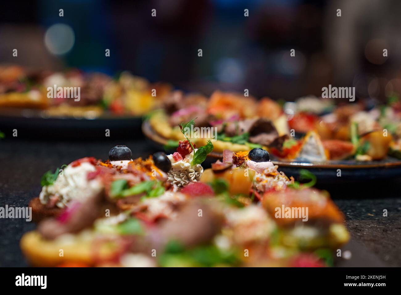 Set of beautiful canapes on black stone plates. Buffet table. Catering ...