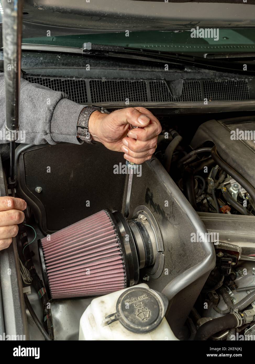 Inside a pickup engine mechanic demonstrates air filter installation ...