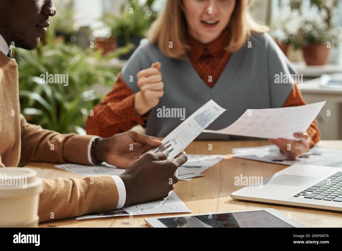 Two colleagues reading documents and discussing them in team during ...