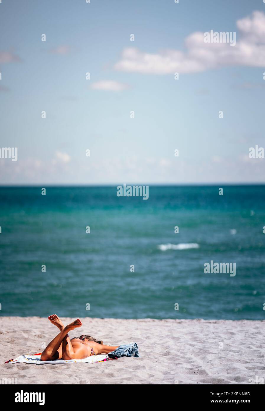 A woman sunbathing on the beach during summer Stock Photo - Alamy