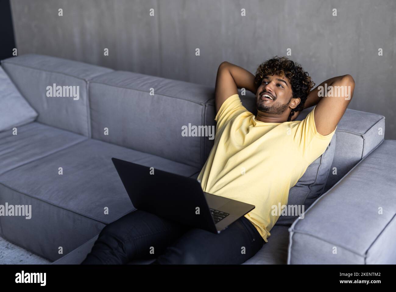 Satisfied relaxed young indian man chilling on sofa in living room ...