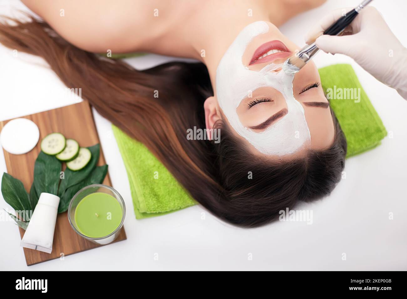 Spa Therapy For Young Woman Receiving Facial Mask At Beauty Salon