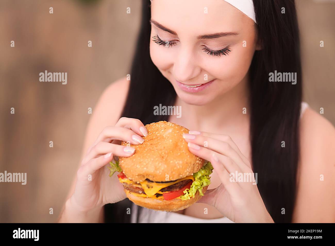 Young woman in a fine dining restaurant eat a hamburger, she behaves ...