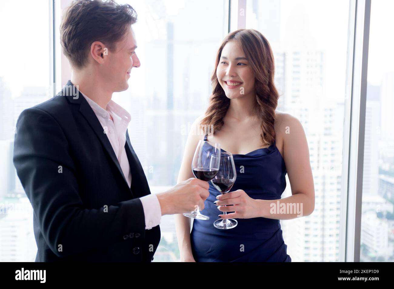 Happy young couple holding with glass of wine cheer together in ...