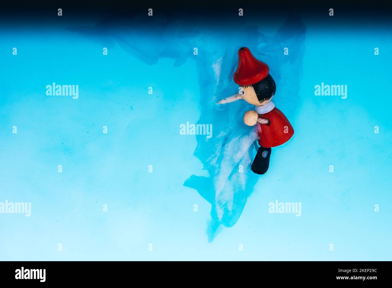 Wodden puppet Pinocchio on in blue water Stock Photo - Alamy