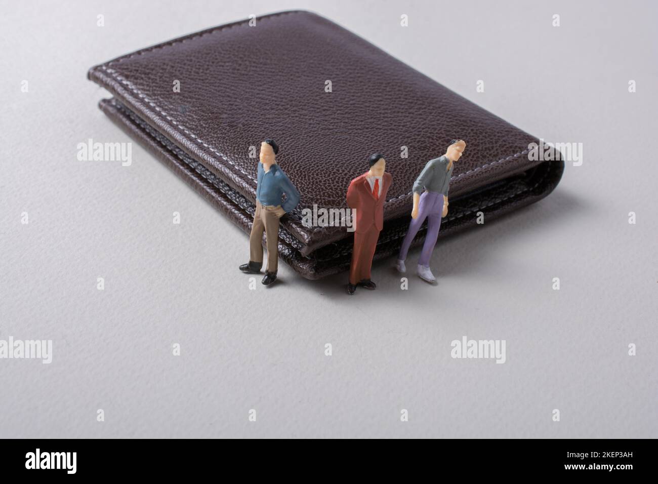 Tiny figurine of men miniature model beside a wallet Stock Photo - Alamy
