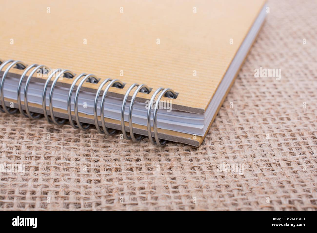 Brown color spiral notebook placed on a canvas background Stock Photo ...