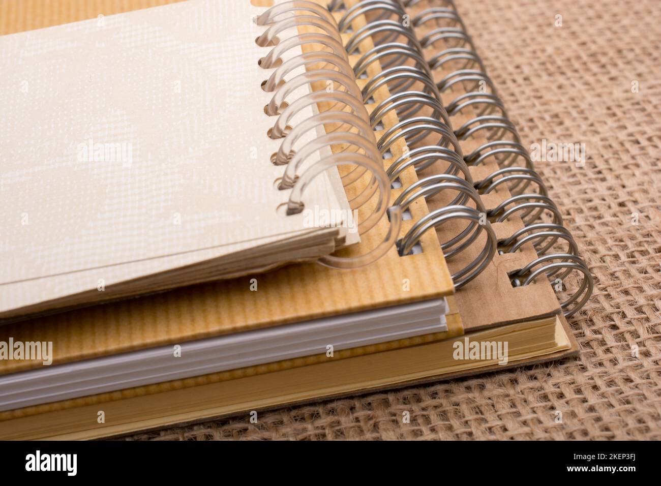 Brown color spiral notebook placed on a canvas background Stock Photo ...