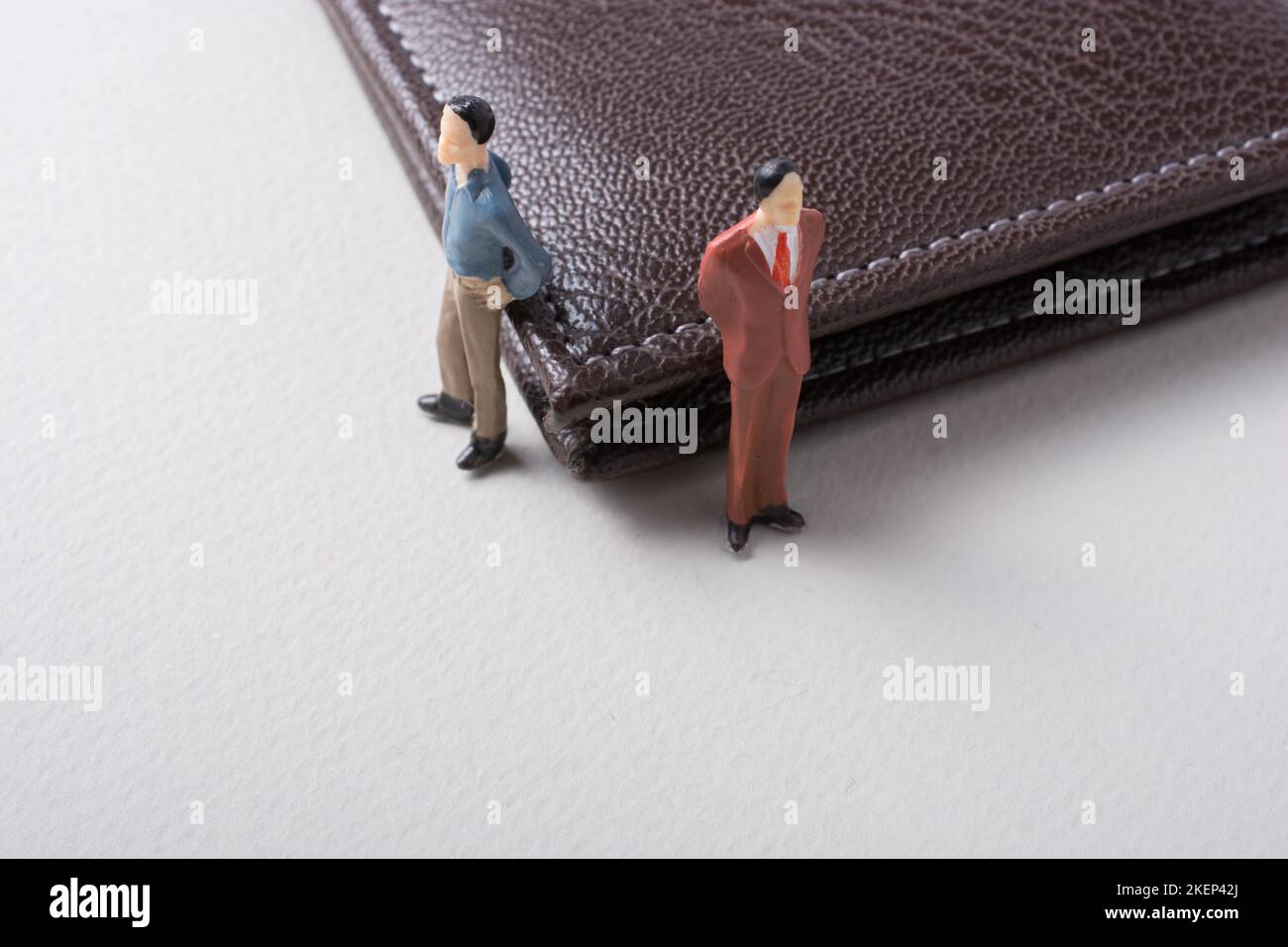 Tiny figurine of men miniature model beside a wallet Stock Photo - Alamy