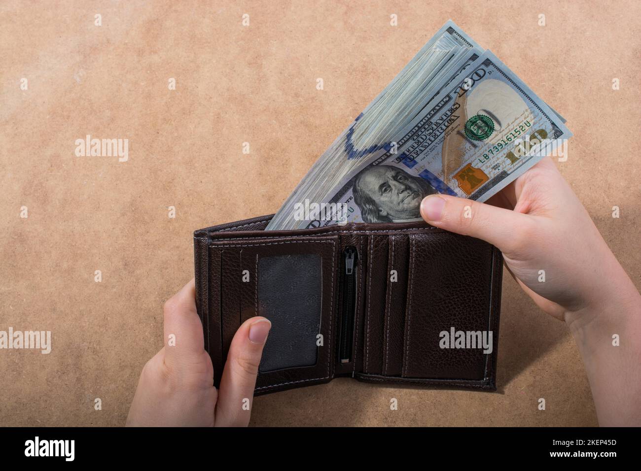 Hand holding American dollar banknotes isolated on wooden background ...