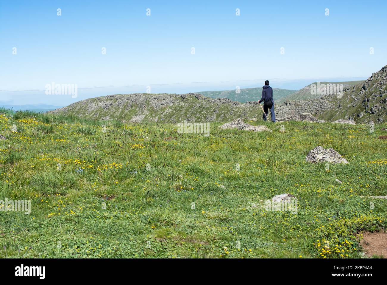 Young man taking an excursion on a mountain Stock Photo - Alamy