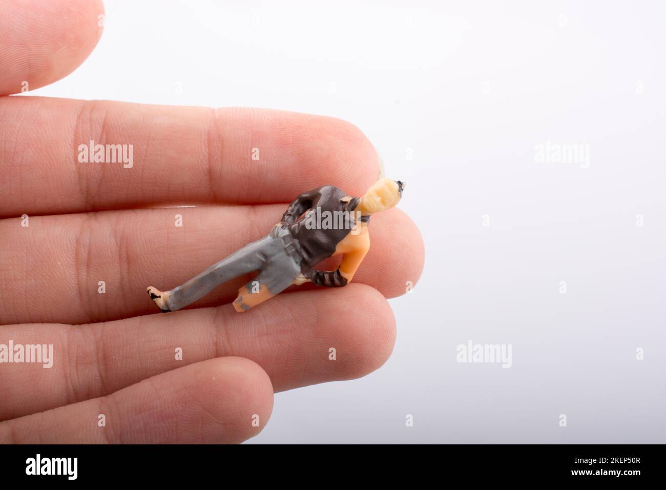 Little man figure with a crippled leg in hand on a white background ...