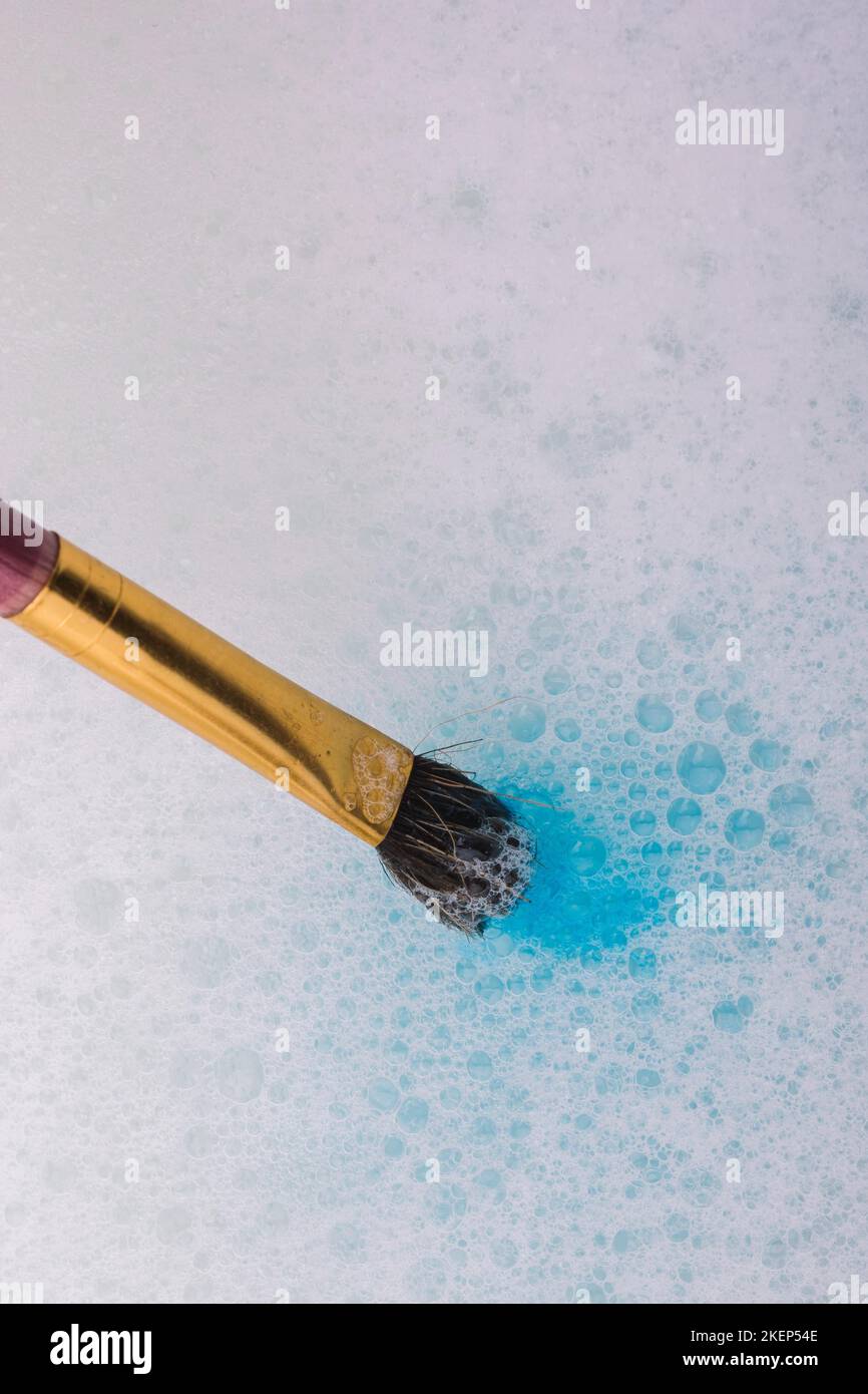 Paint dissolving in water as painting brush touching water Stock Photo ...