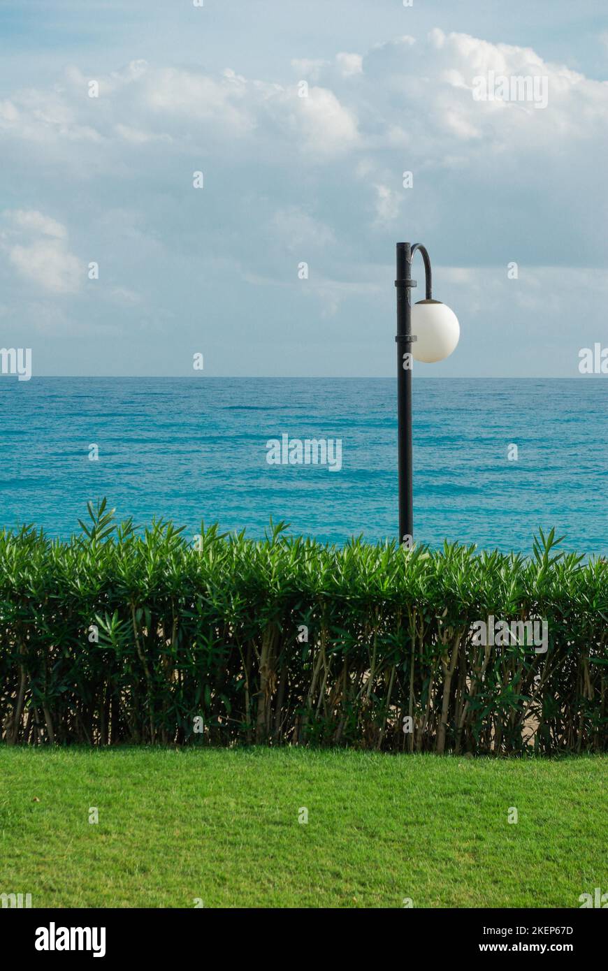Street lamp between the green grass and the blue sea Stock Photo - Alamy
