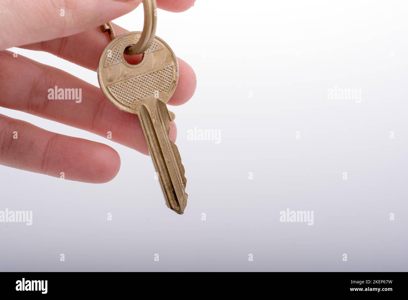 Hand holding a golden color key in hand Stock Photo - Alamy