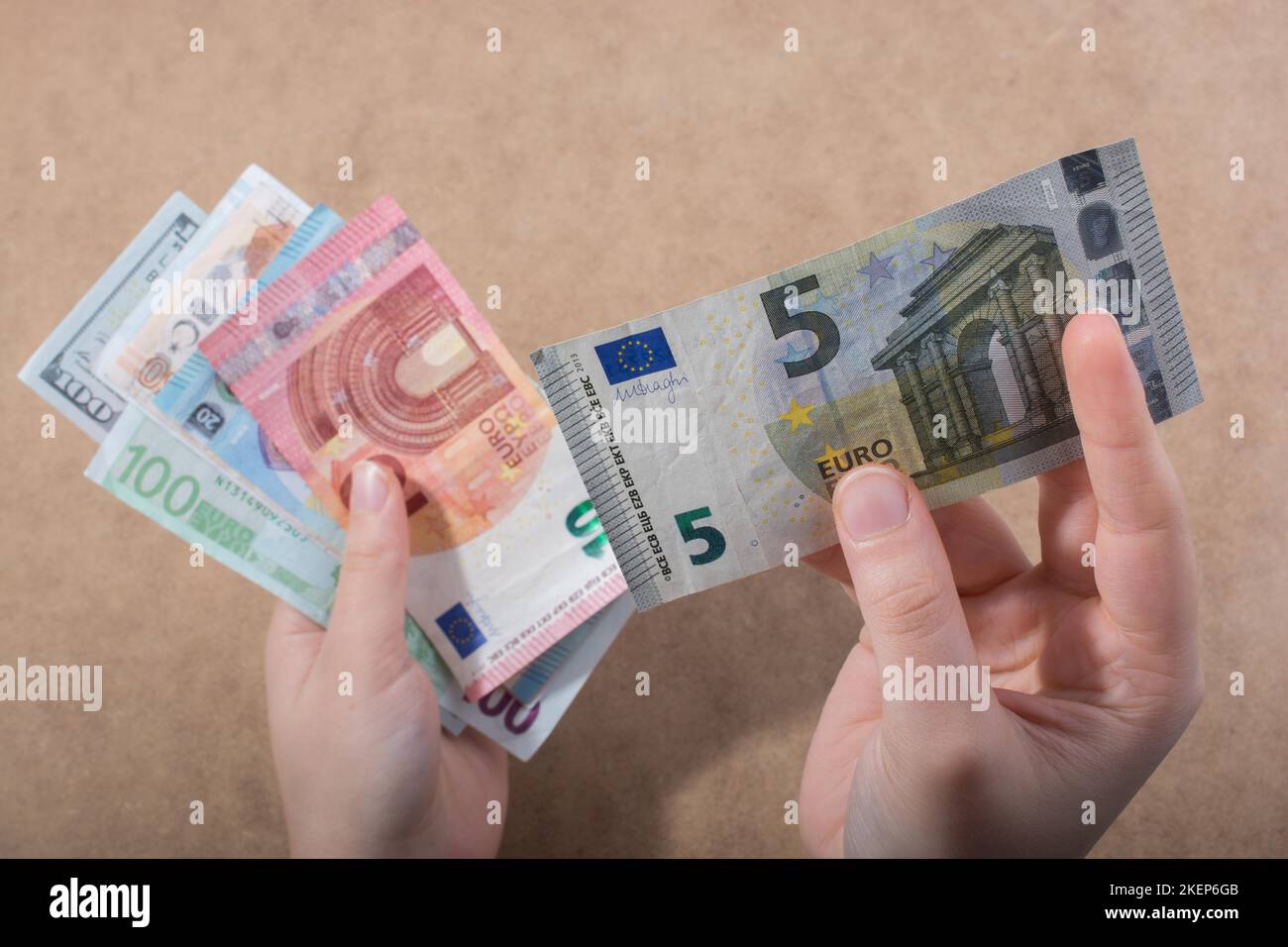 Hand holding American dollar banknotes isolated on wooden background ...