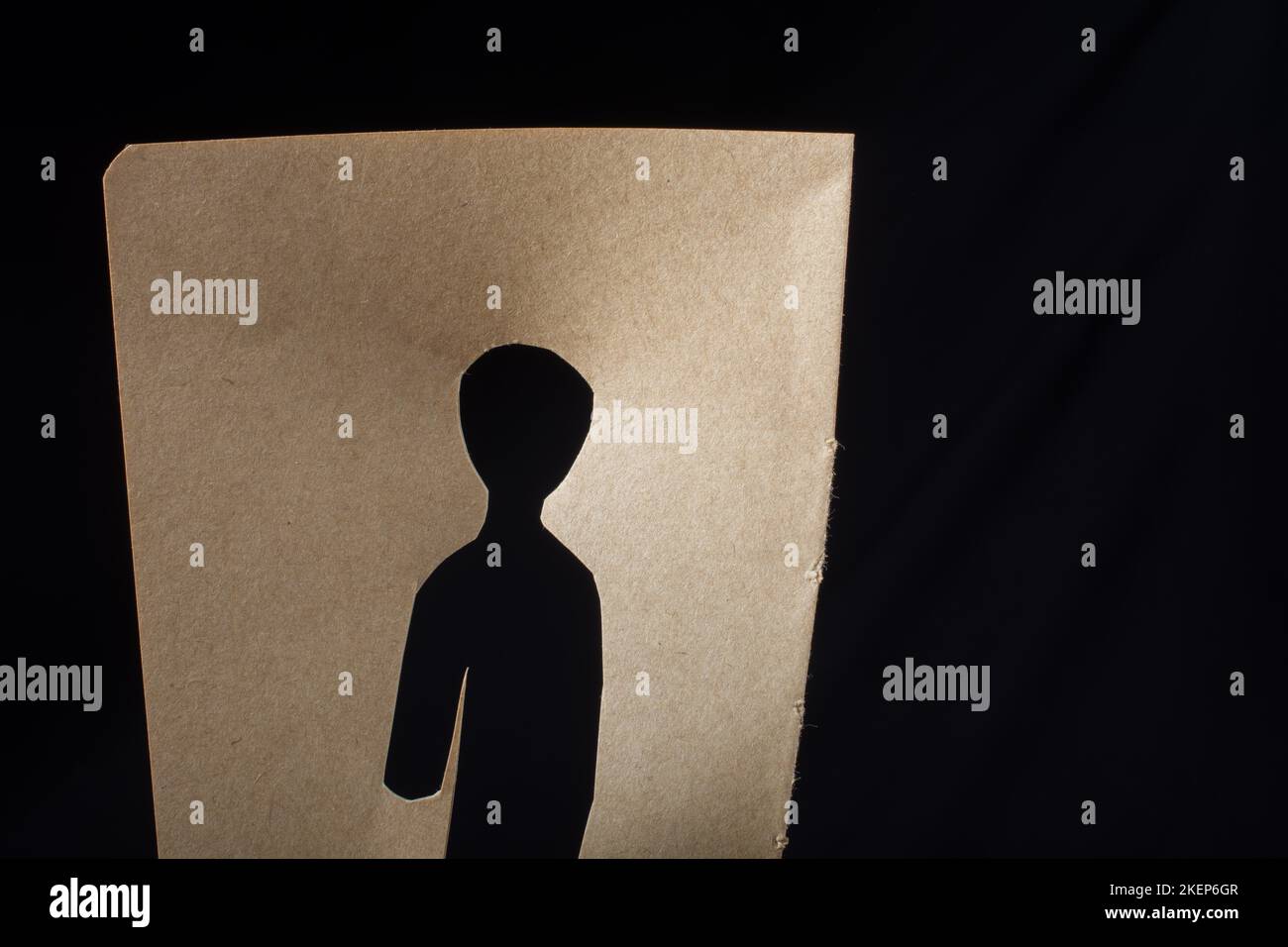Man shape cut out of paper in hand in the view Stock Photo - Alamy