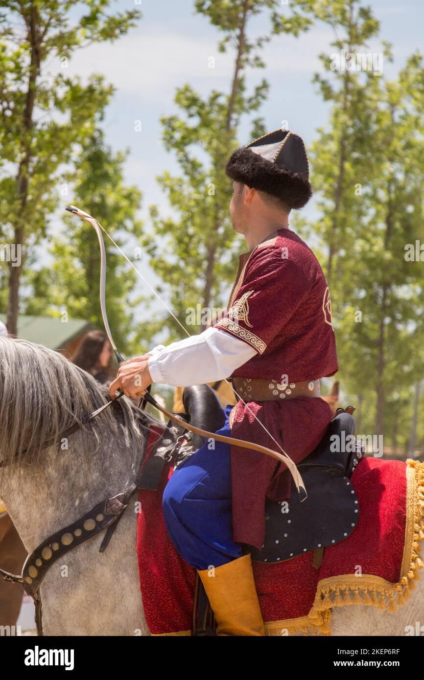 Archer with bow in traditional clothes shooting an arrow Stock Photo ...