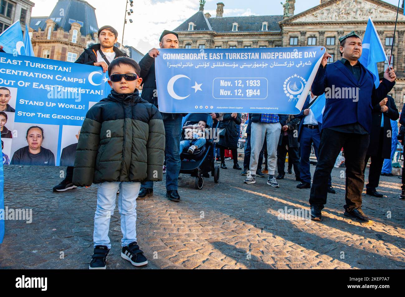 A little Uyghur boy is seen standing in front of banners in support of ...
