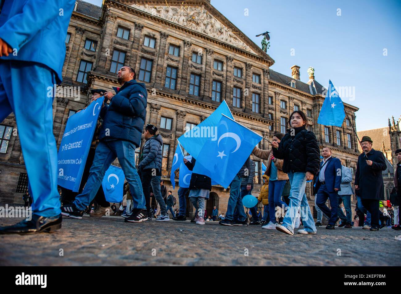 Uyghur people are seen marching around the square holding Uyghur flags ...
