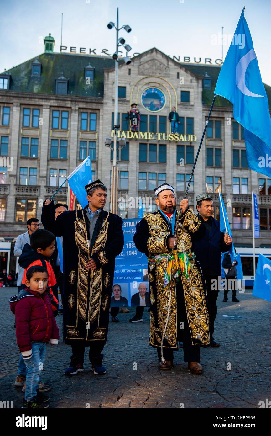 Uyghur men wearing traditional clothes are seen standing up in the ...