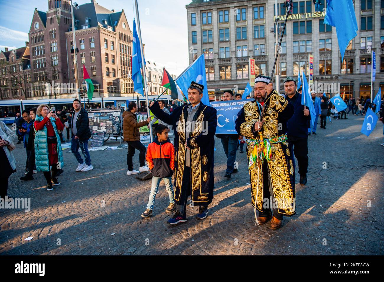 Two Uyghur men wearing traditional Uyghur clothes walk around the ...