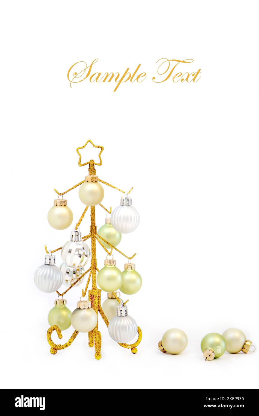 Tiny gold metal Christmas tree with soft coloured balls in vertical ...