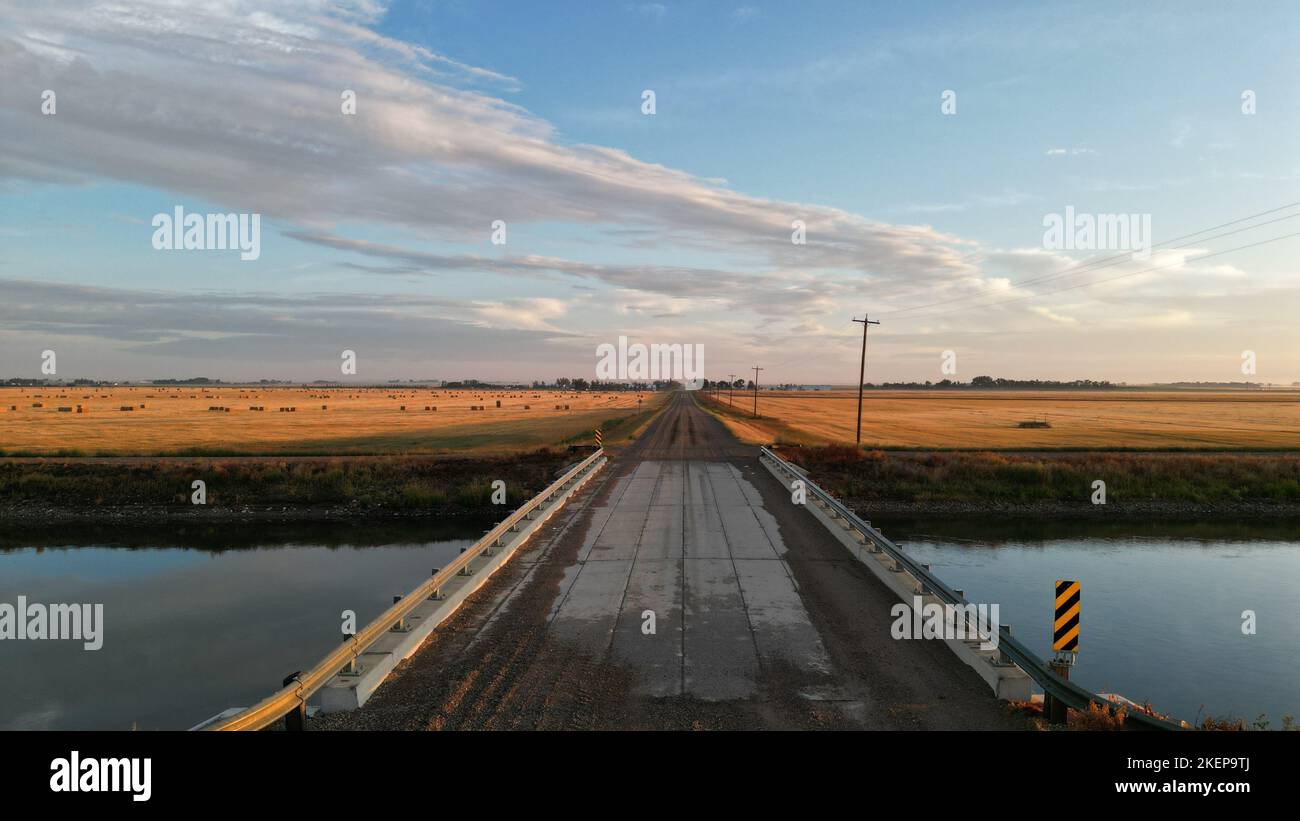 Drone view during sunrise over a farm hay field and river in Alberta ...