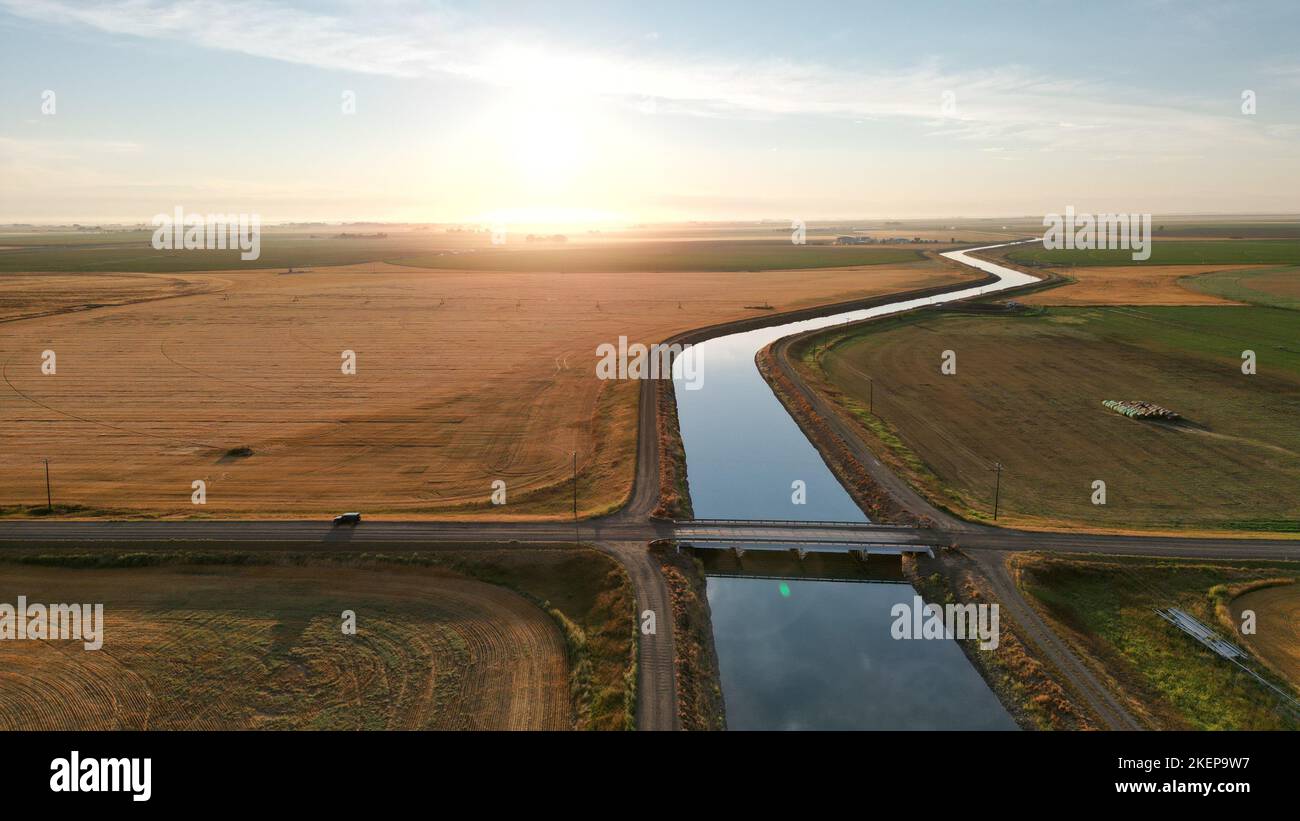 Drone view during sunrise over a farm hay field and river in Alberta ...